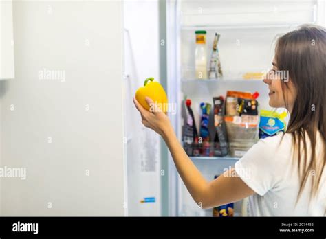 Beautiful Young Woman Near The Refrigerator With Healthy Food Fruits