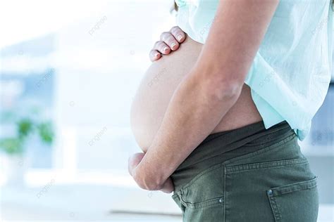 Midsection Of Pregnant Woman Touching Belly Expecting Standing Admiring Photo Background And