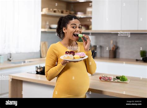Cheerful Pretty Young Black Pregnant Woman With Big Belly Eats Sweets