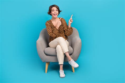 전체 길이 사진 놀란 긍정적 인 사람이 편안한 의자에 앉아 직접 손가락 빈 공간 파란색 배경에 고립 25 29세에 대한 스톡 사진 및 기타 이미지 Istock