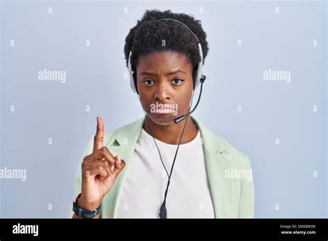 African American Woman Wearing Call Center Agent Headset Pointing Up