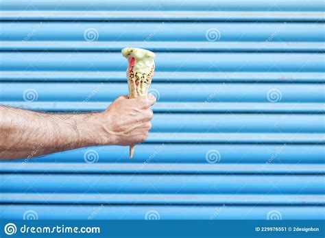 Manand X27 S Hand Holding An Ice Cream Cone Melting Over A Light Blue