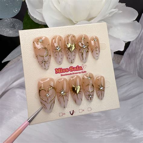 Golden Nude Mystery Nude Almond Nails With 3d Gold Celestial And Heart