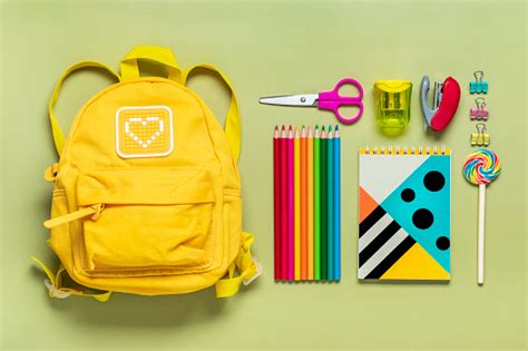 학교 교육 개념으로 돌아가기 학용품이 있는 노란색 배낭 노트북 펜 지우개 무지개 녹색 배경에 격리된 숫자 상위 뷰 복사 공간 플랫 레이 구성 배너 0명에 대한 스톡 사진 및