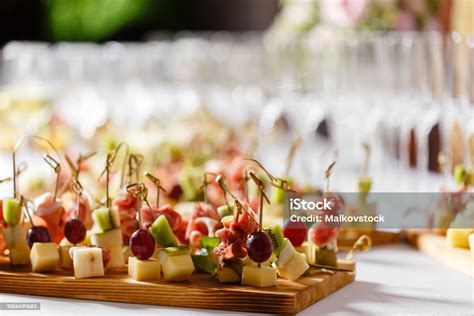 리셉션에서 뷔페입니다 포도주와 샴페인의 유리입니다 그러길 래 나무 보드의 구색입니다 연회 서비스입니다 치즈 Jamon 햄과 과일 스낵 식품 음식 특별 할인 시간대에 대한