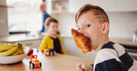 부엌에서 어머니와 함께 식사를 하는 두 명의 쾌활한 어린 아이들 사진 Unsplash의 크루아상 이미지