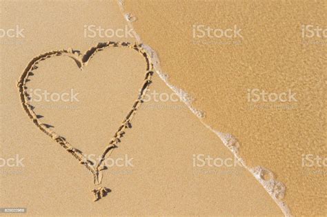 심장 텍스트에 대 한 장소를 가진 아침에는 바다의 파도와 해변의 모래에 그려진 여름 휴가 개념 로맨틱 사랑 배경입니다 발렌타인