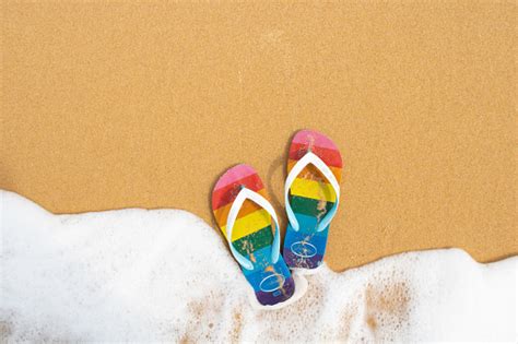 Lgbtq Flag Flipflop In A Sand And A Ocean Wave Top View Of A Wave In A
