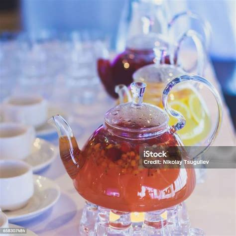촛불이있는 테이블에 사과 레몬 생강이있는 맛있는 녹차와 함께 투명한 주전자 주전자의 아름다운 따뜻한 그림과 배경에 디저트가 있습니다n 0명에 대한 스톡 사진 및 기타 이미지