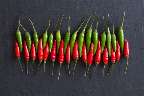 블랙 테이블에 검은 어두운 배경에 빨간색 뜨거운 칠리 고추 붉은 고추 고추의 많은 텍스트의 공간을 복사 합니다 평면 누워 평면도 레드와 그린 칠리 고추 성애를 다룬 문학