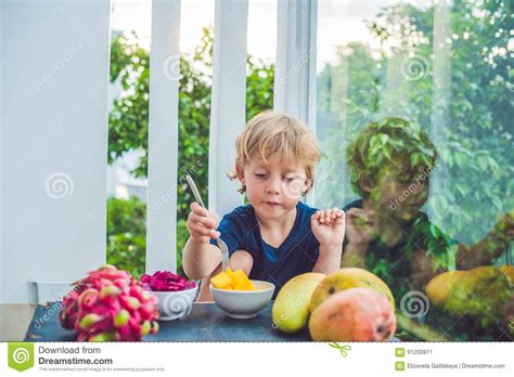 Kleiner Netter Junge Der Mango Auf Der Terrasse Isst Stockbild Bild