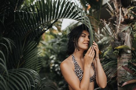 Mujer emocionada con cabello oscuro posando en el exótico resort mujer joven guapa