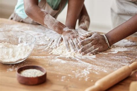 Mother And Daughter Baking Together In Kitchen And Kneading Dough Stock
