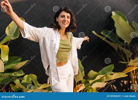 Stylish Young Caucasian Girl Enjoys Free Time Standing Near Black Wall