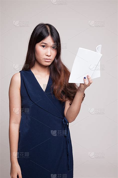 年轻的亚洲女人拿着一本书。