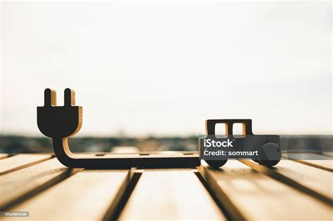 전선과 리튬 배터리가 있는 목조 자동차 연결된 충전 케이블이 있는 기술 배터리 고출력 전기 에너지 깨끗한 전기로 전기 자동차 및