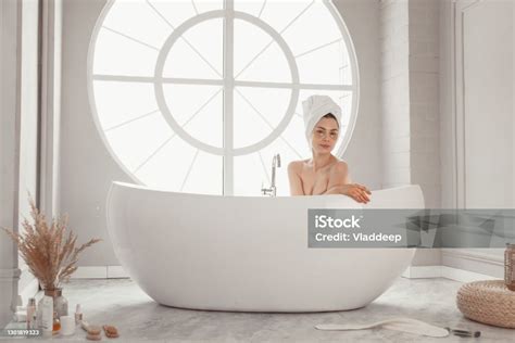Young Woman Relaxing Lying In Bathtube In Luxury Bathroom With Round