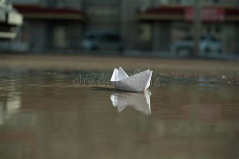 A Boat Of Documents Floats In The Spring On A Puddle In The City Stock