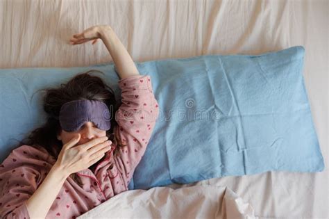 Happy Woman In Bed Wakes Up Person In Sleep Mask Stretches And Yawns