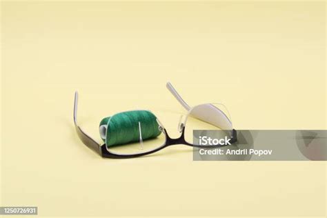 반전 된 안경에서 노란색 배경에 바늘이있는 스레드를 볼 수 있습니다 구멍에 대한 스톡 사진 및 기타 이미지 구멍 날카로운