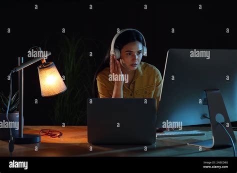 Programmer With Headphones Working In Office At Night Stock Photo Alamy