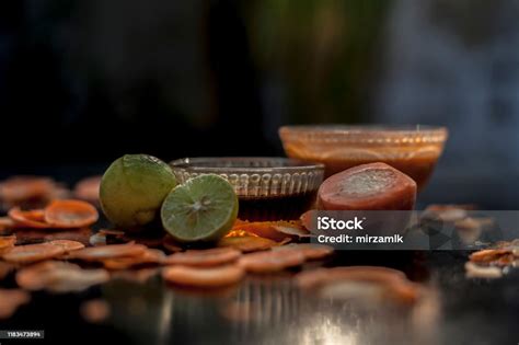 갓 썬 당근 페이스트 레몬 주스 꿀로 구성된 검은 색 나무 표면에 당근 얼굴 마스크는 여드름 치료를위해 유리 그릇에 잘 섞여