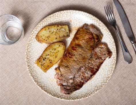 Carne De Ternera Asada Con Patatas Fritas Servida En La Mesa Foto De