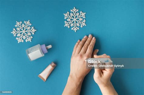 겨울철에는 보습 핸드 크림 사용 다른 스킨 케어 제품 옆에 파란색 배경에 흰색 크림을 칠하는 여성 손 피부 광고 치료 개체
