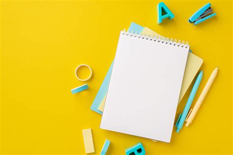 학교 액세서리 개념 문구 메모장 플라스틱 알파벳 글자 미니 스테이플러 접착 테이프 지우개와 빈 공간이있는 고립 된 노란색 배경에