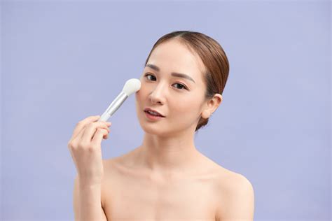 뷰티 페이스 화장품 브러시와 느슨한 홍당무를 적용 하는 아름 다운 웃는 여자의 초상화입니다 메이크업 화장품에 대한 스톡 사진 및