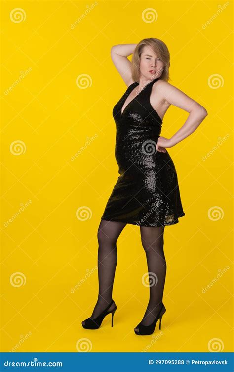 Full Length Photo Of Curvy Mature Blonde In Party Dress One Hand Behind Head Looking At Camera