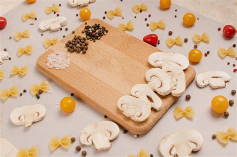 베이지 색 배경 상단보기 클로즈업에 조리되지 않은 파스타 토마토 버섯 슬라이스와 향신료 요리 페투치네 노란색과 빨간색 체리 개체