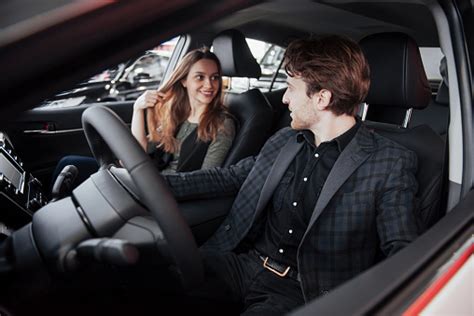 그들의 결정을 만들기 아름 다운 부부 대리점 잘생긴 남자와 그의 사랑 여자 친구 차 함께 소비 차량 선택에서 새 차에 함께 앉아 사랑 계약서에 대한 스톡 사진 및 기타