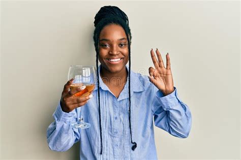African American Woman With Braided Hair Drinking A Glass Of White Wine