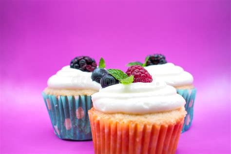 Cupcakes De Fruta Cobertura Branca Em Fundo Roxo Isolado Imagem De Stock Imagem De Doce