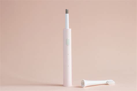 밝은 베이지 색 배경에 분해 된 전기 초음파 칫솔 구강 관리 및 치아 건강을위한 혁신적인 기술 복사 공간 칫솔에 대한 스톡 사진