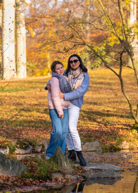 Happy Single Mom And Her Teenage Daughter On Walk In Fall Park Mom