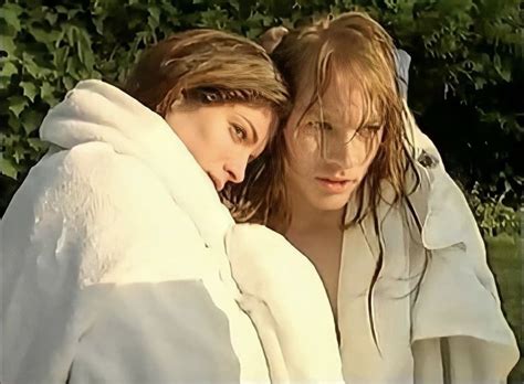 Two Women Wrapped In White Robes Standing Next To Each Other