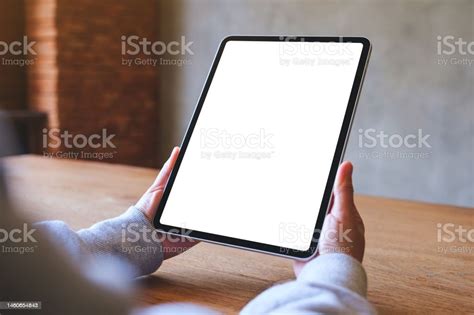 나무 테이블에 빈 흰색 데스크톱 화면이 있는 디지털 태블릿을 들고 있는 여성의 모형 이미지 35 39세에 대한 스톡 사진 및