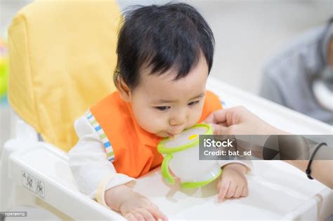 높은 자에 9 개월 여자 아시아 아기를 먹이 엄마는 그녀의 딸에 게 식 수를 피드 전통적인 이유 가족에 대한 스톡 사진 및 기타 이미지 Istock