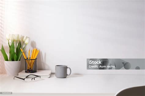 흰색 테이블에 화분 커피 컵 연필꽂이가 있는 여성스러운 현대적인 직장 광고 문구를 위한 공간을 복사합니다 0명에 대한 스톡 사진