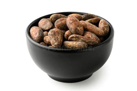 Roasted Unpeeled Cocoa Beans In A Black Ceramic Bowl Isolated On White