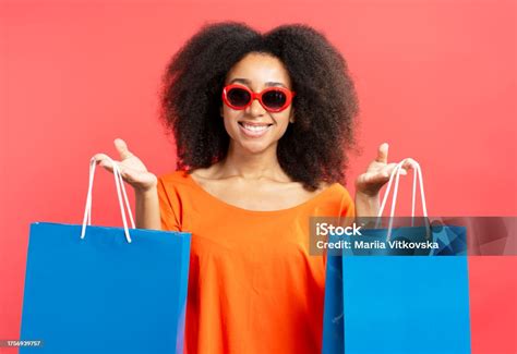 빨간 배경에 고립된 쇼핑백을 들고 선글라스를 끼고 웃는 여자 쇼핑 컨셉 25 29세에 대한 스톡 사진 및 기타 이미지 25 29세 검은색 고객 Istock