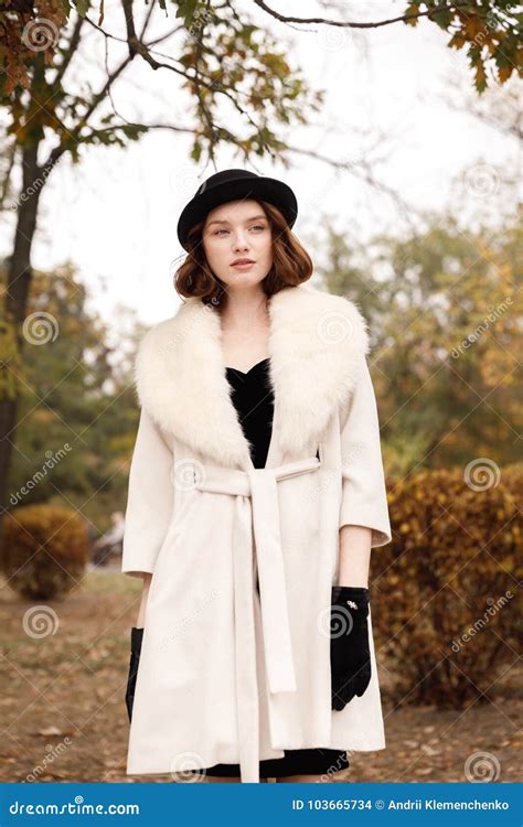 Retro Gangster Girl In Black Hat And Coat In Autumn Park Looks Aside