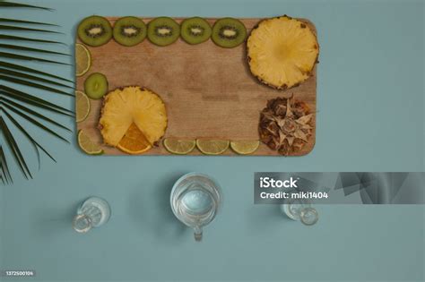 손바닥 잎과 안경과 밝은 파란색 배경에 나무 접시에 이국적인 여름 과일 슬라이스 최소한의 과일 플랫 평신도 장면 0명에 대한