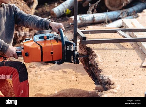 Closeup Of Lumberjack Cutting Tree Trunk With Giant Chainsaw To Make