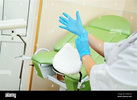 Gynecologist Putting On Rubber Gloves Prepares For Examination Against The Background