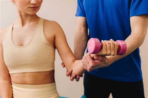 치료사는 환자가 질병 후 팔 움직임을 회복하도록 돕고 있습니다 의사는 신체 기능을 회복하기 위해 물리 치료를 돕고 있습니다 부상 치유에 효과적인 Pt 25 29세에 대한