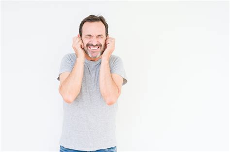 시끄러운 음악의 소음에 대 한 짜증이 식이 손가락으로 귀를 덮고 격리 된 배경 위에 잘생긴 수석 남자 청각 장애인 개념입니다 가리기에 대한 스톡 사진 및 기타 이미지