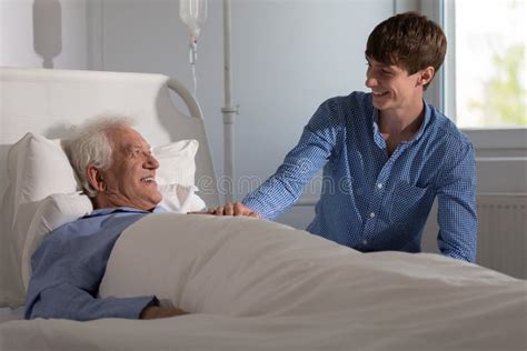 Nieto Que Visita Al Abuelo Enfermo Imagen De Archivo Imagen De
